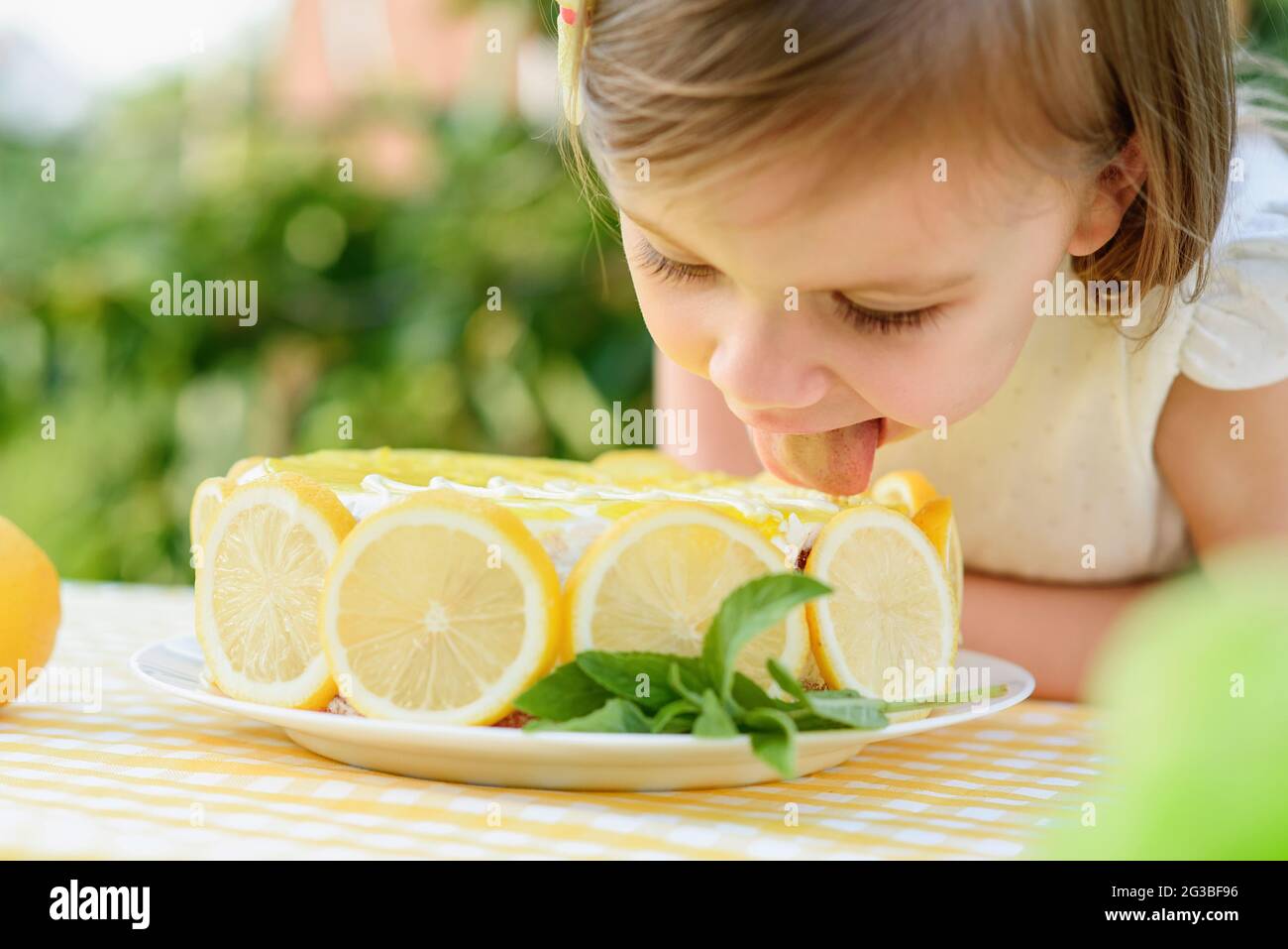girl eating lemon Birthday cake. Lemonade birthday party at summer park ...
