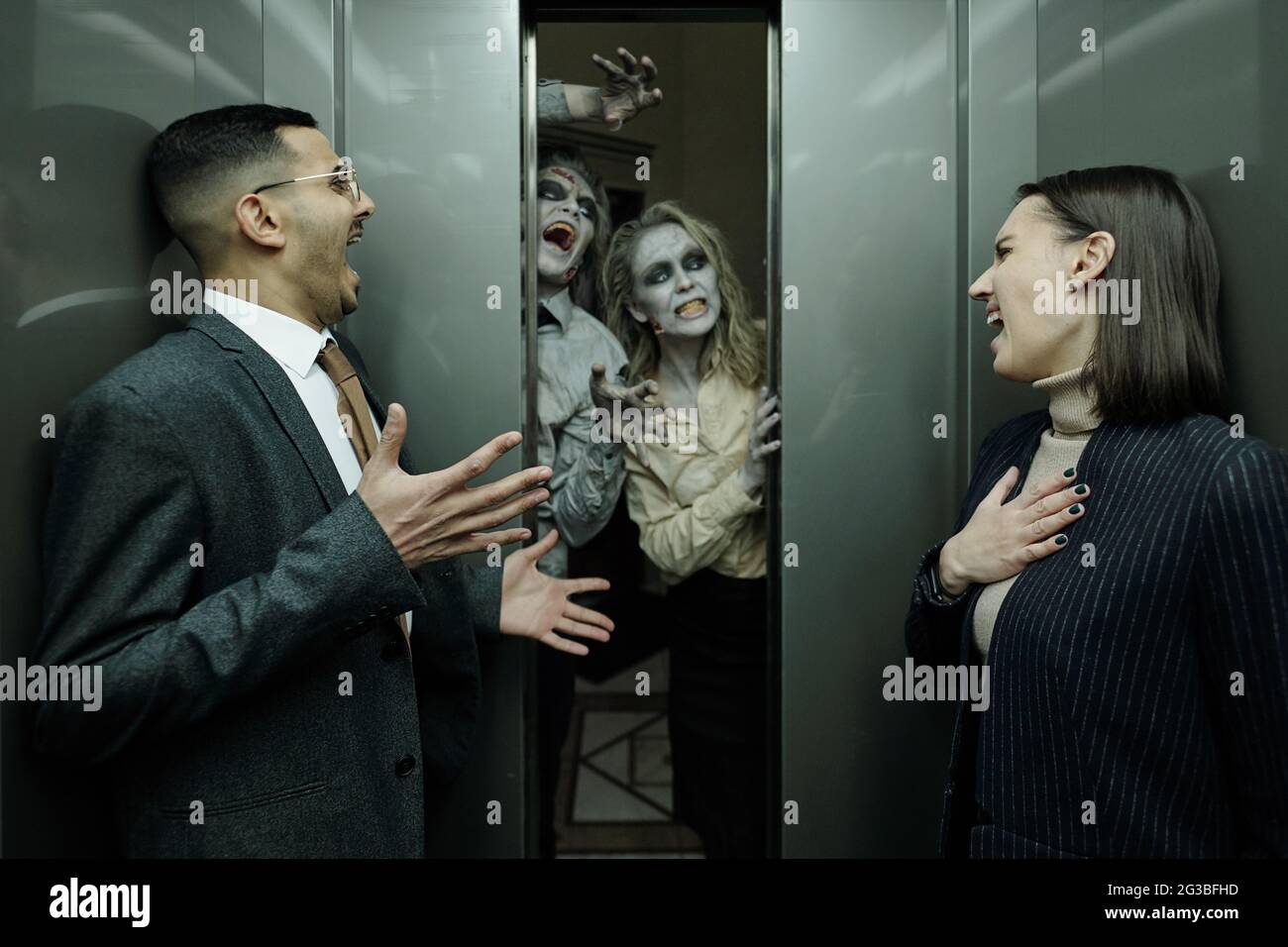 Terrified office managers screaming in elevator while zombies ...