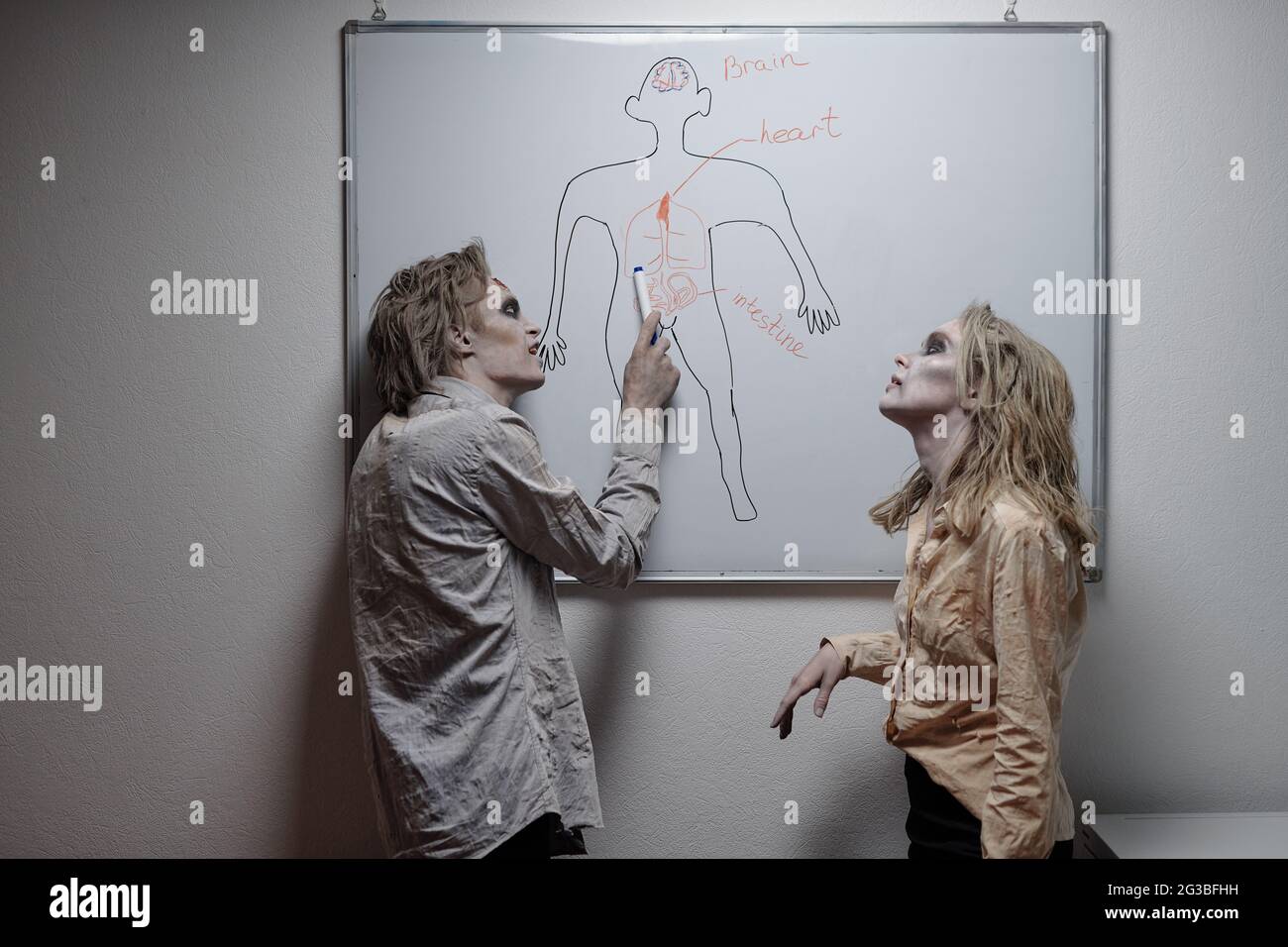 Two zombies discussing drwing of human body parts by white wall Stock ...
