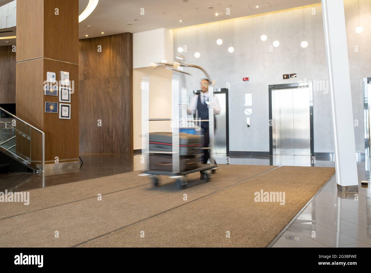 Blurred motion of porter pushing cart with suitcases Stock Photo - Alamy