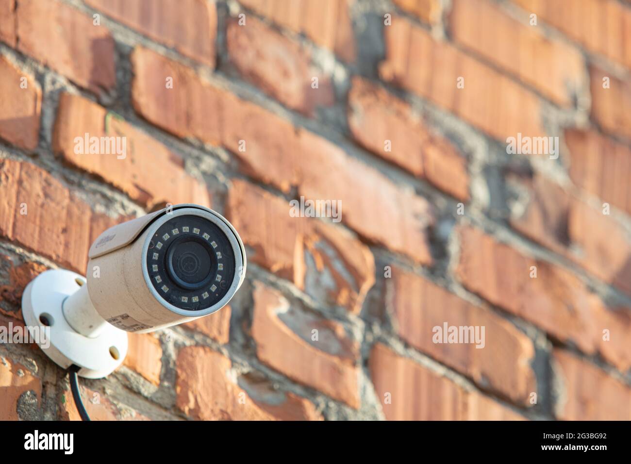 security camera on red brick wall background Stock Photo - Alamy