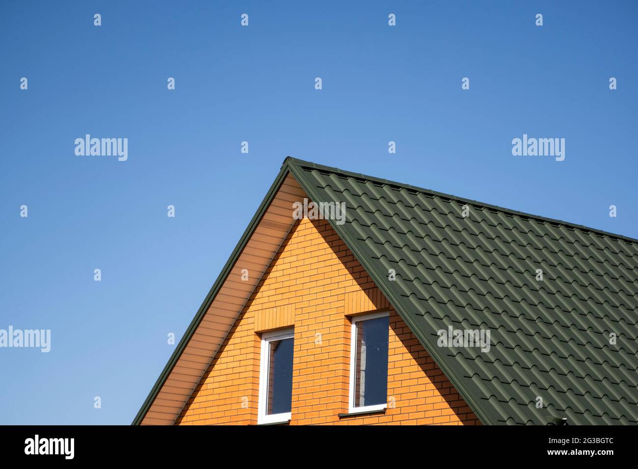Green corrugated metal profile roof installed on a modern house. The ...