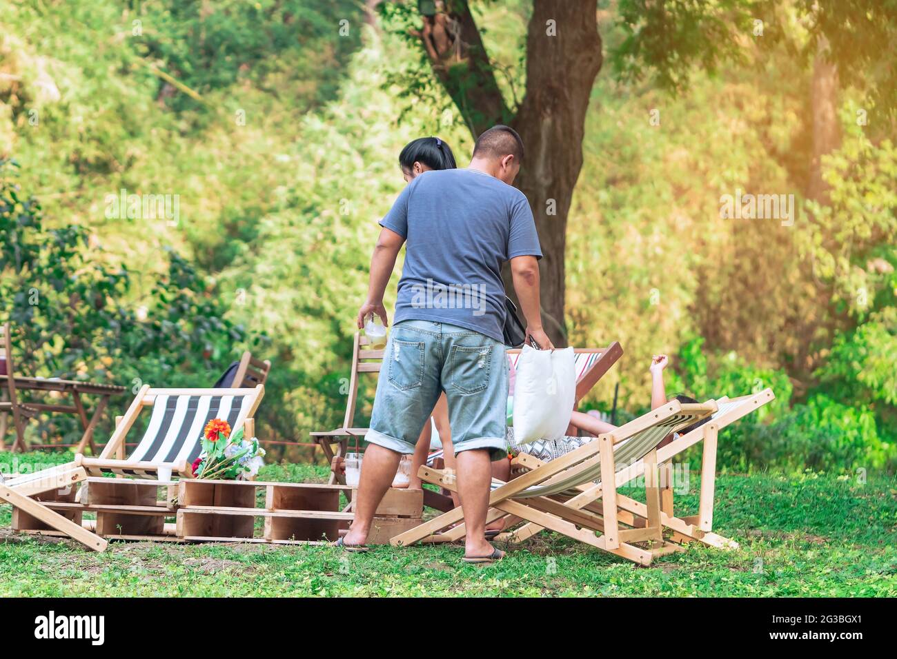 Back view of Asian couple prepare to sit and relax together on garden ...