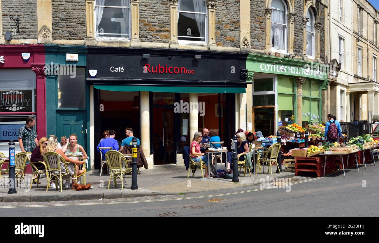 Restaurant with customers eating outside on pavement and fruit and veg ...
