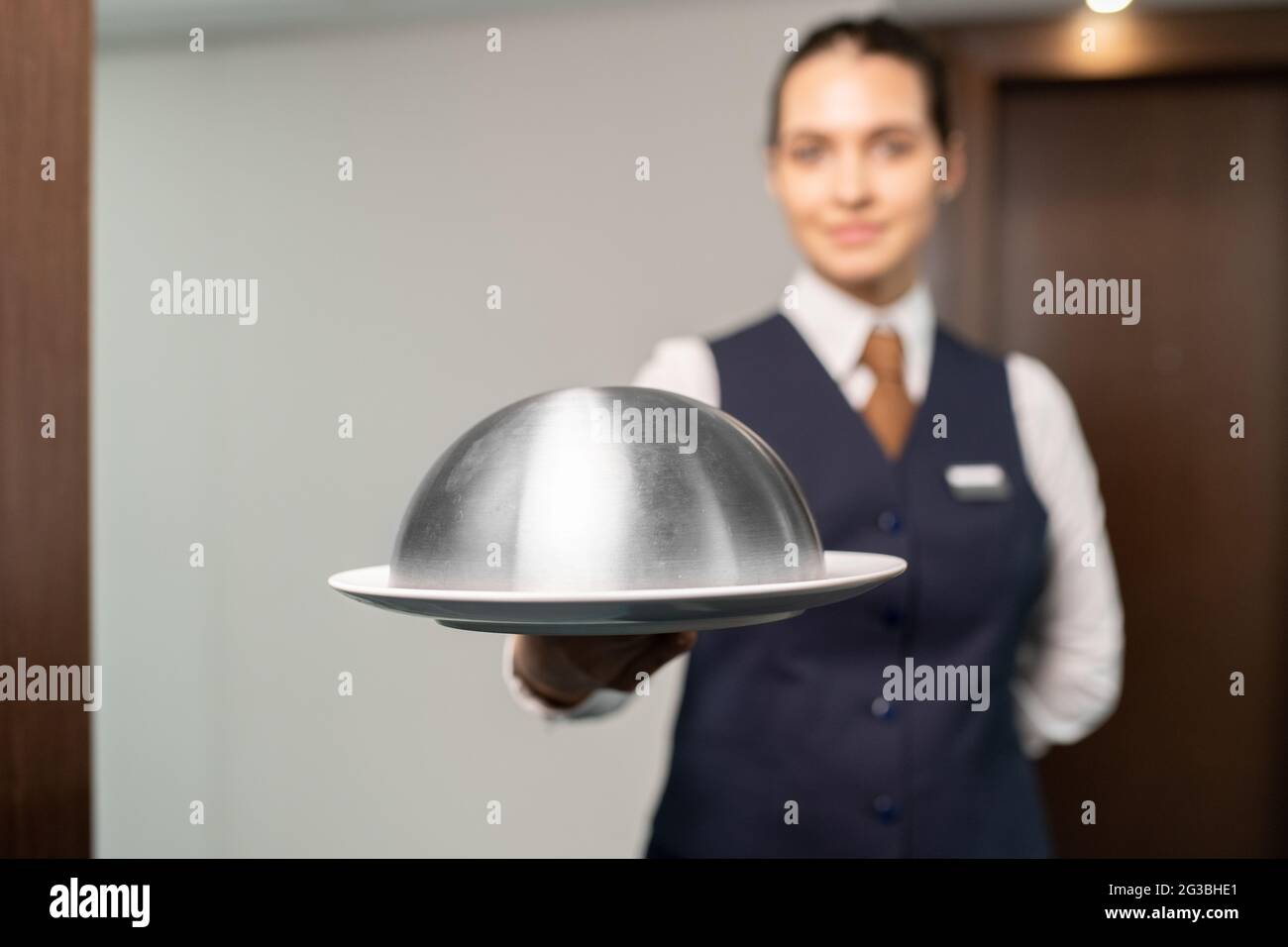 Tray with breakfast held by young female chambermaid in uniform Stock ...