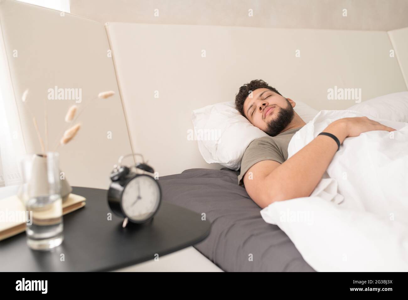 Peaceful young man sleeping in bed in hotel room Stock Photo - Alamy
