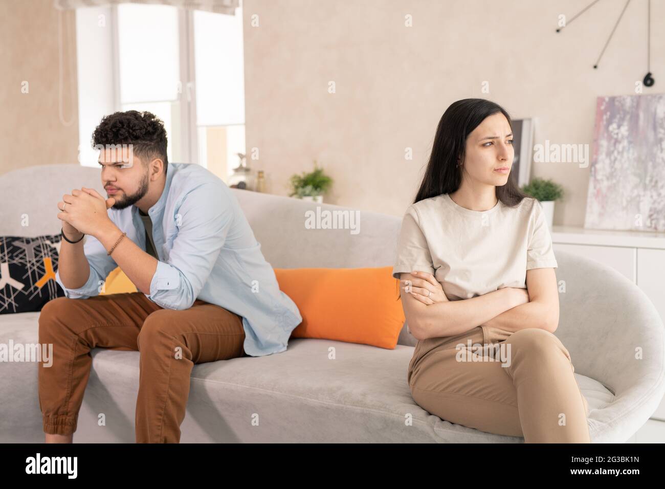 Upset husband and wife sitting on couch after having argument Stock ...