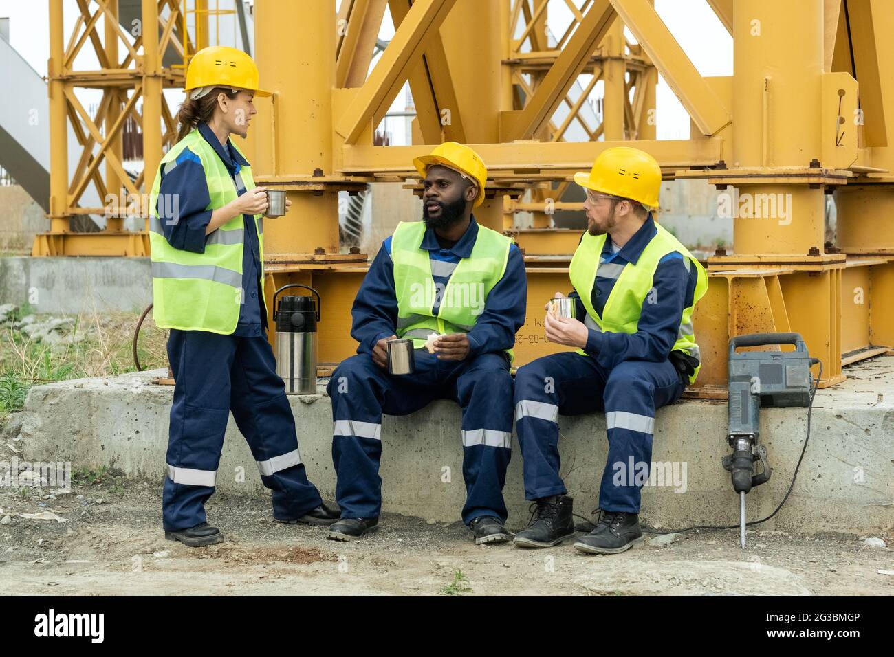 Group of builders talking while having lunch on construction site Stock ...