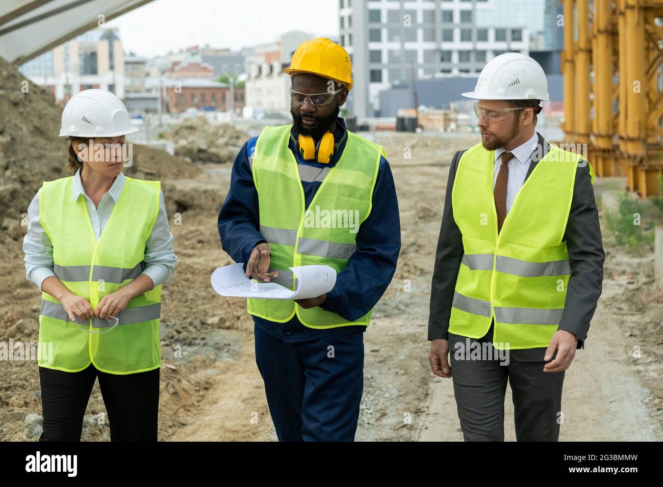 Young African builder explaining sketch of construction to colleagues ...