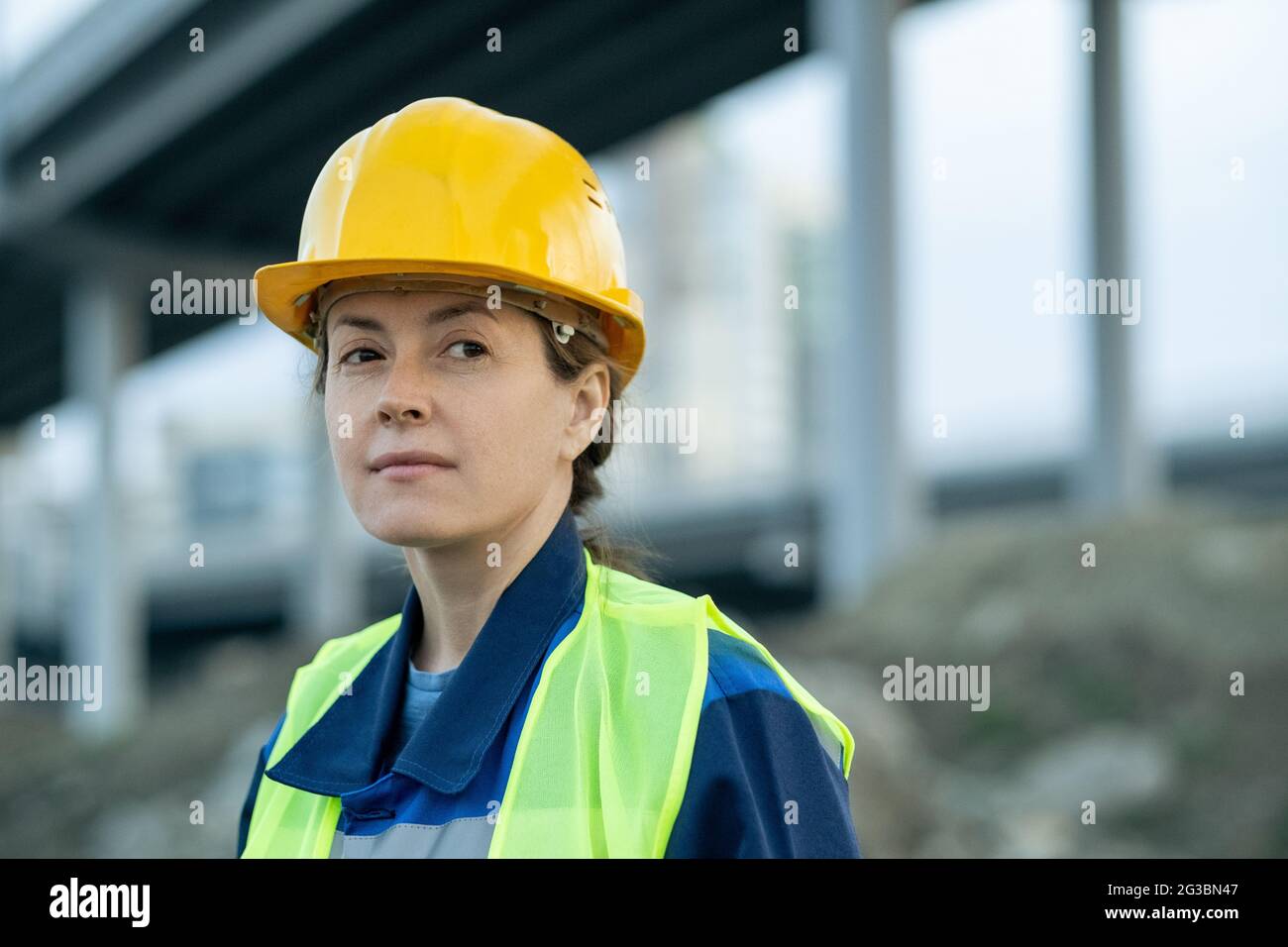 Young female builder in hardhat and uniform on construction site Stock ...