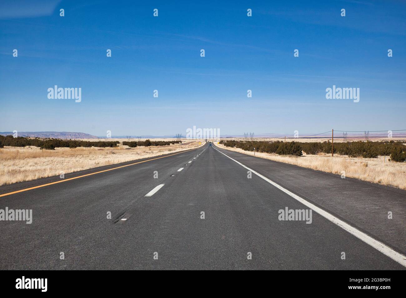View along a long stretch of road through semi desert in Arizona on the ...