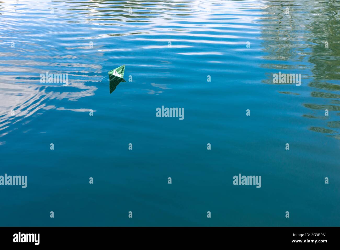 White paper skiffs float on water. Origami Stock Photo - Alamy