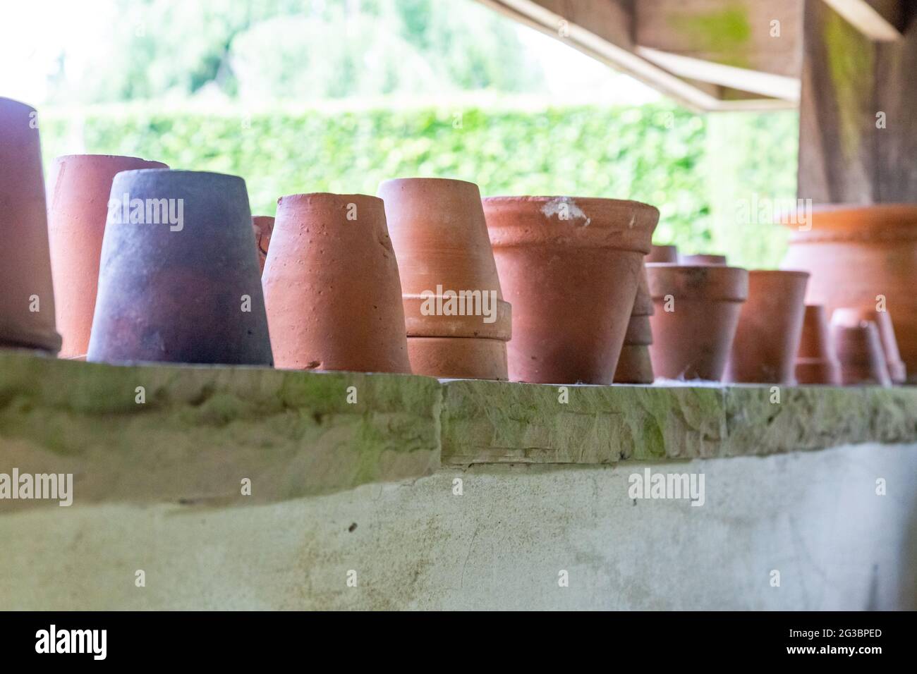 An assortment of clay plant pots stored on a shelf Stock Photo - Alamy