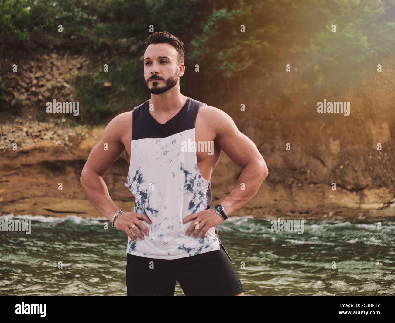 Handsome athletic young man near river, standing Stock Photo - Alamy
