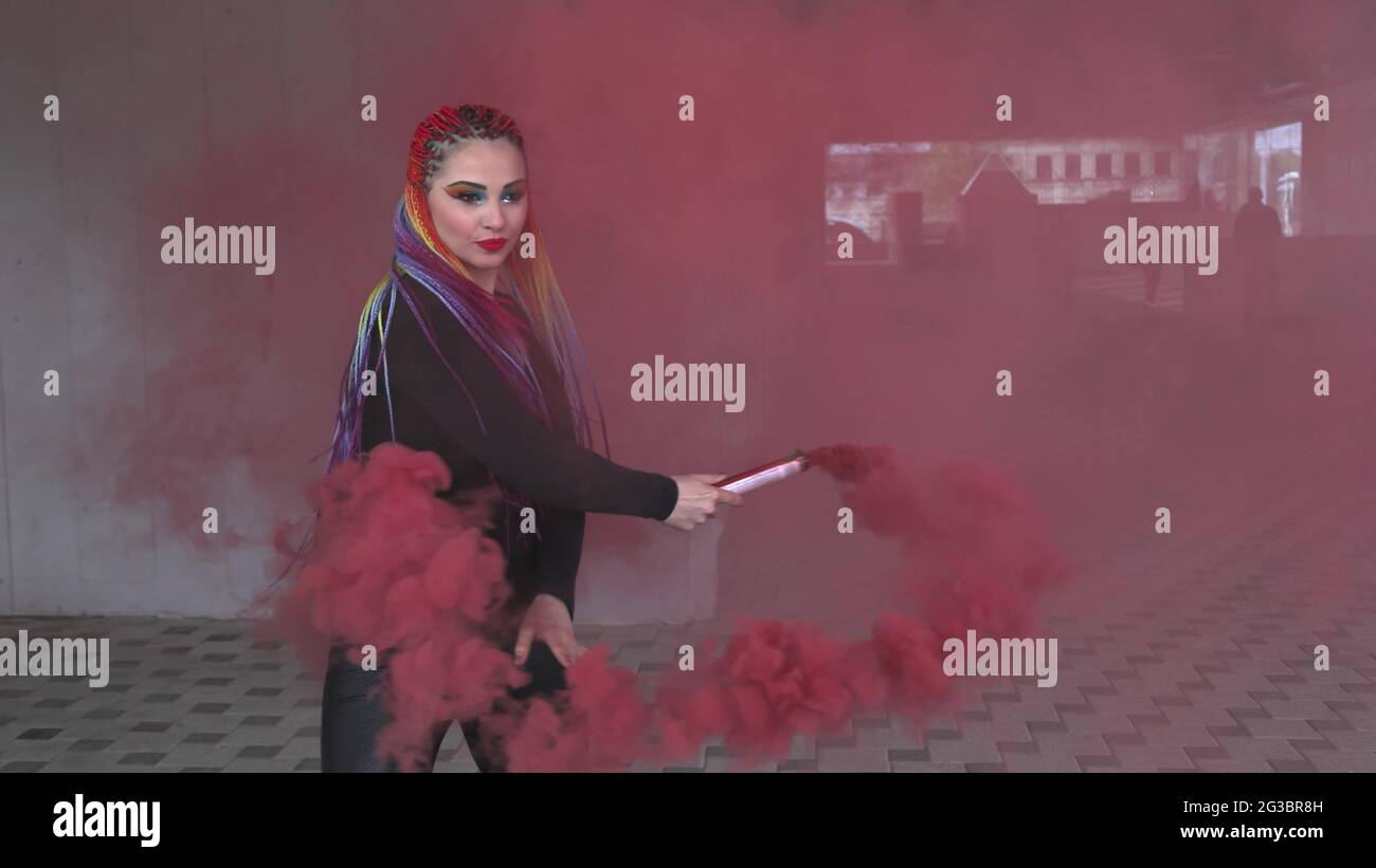 Attractive girl with multicolored braids and makeup in an black dress ...