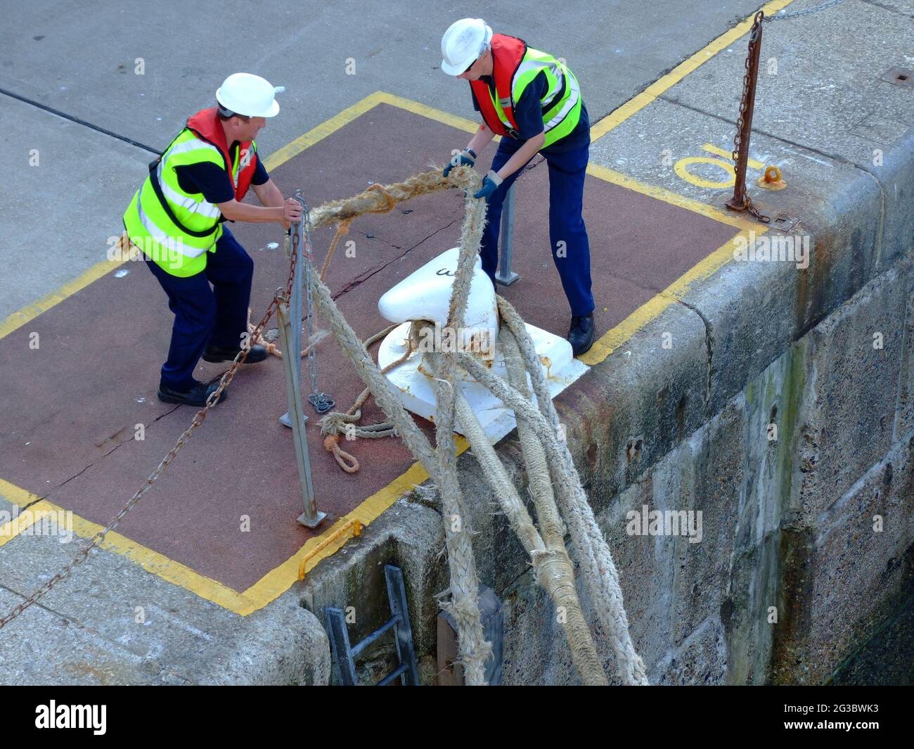Dock side workers casting off cruise ship Stock Photo - Alamy