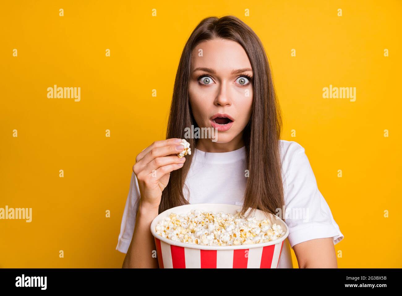 Photo portrait of shocked girl eating pop corn watching horror movie in ...
