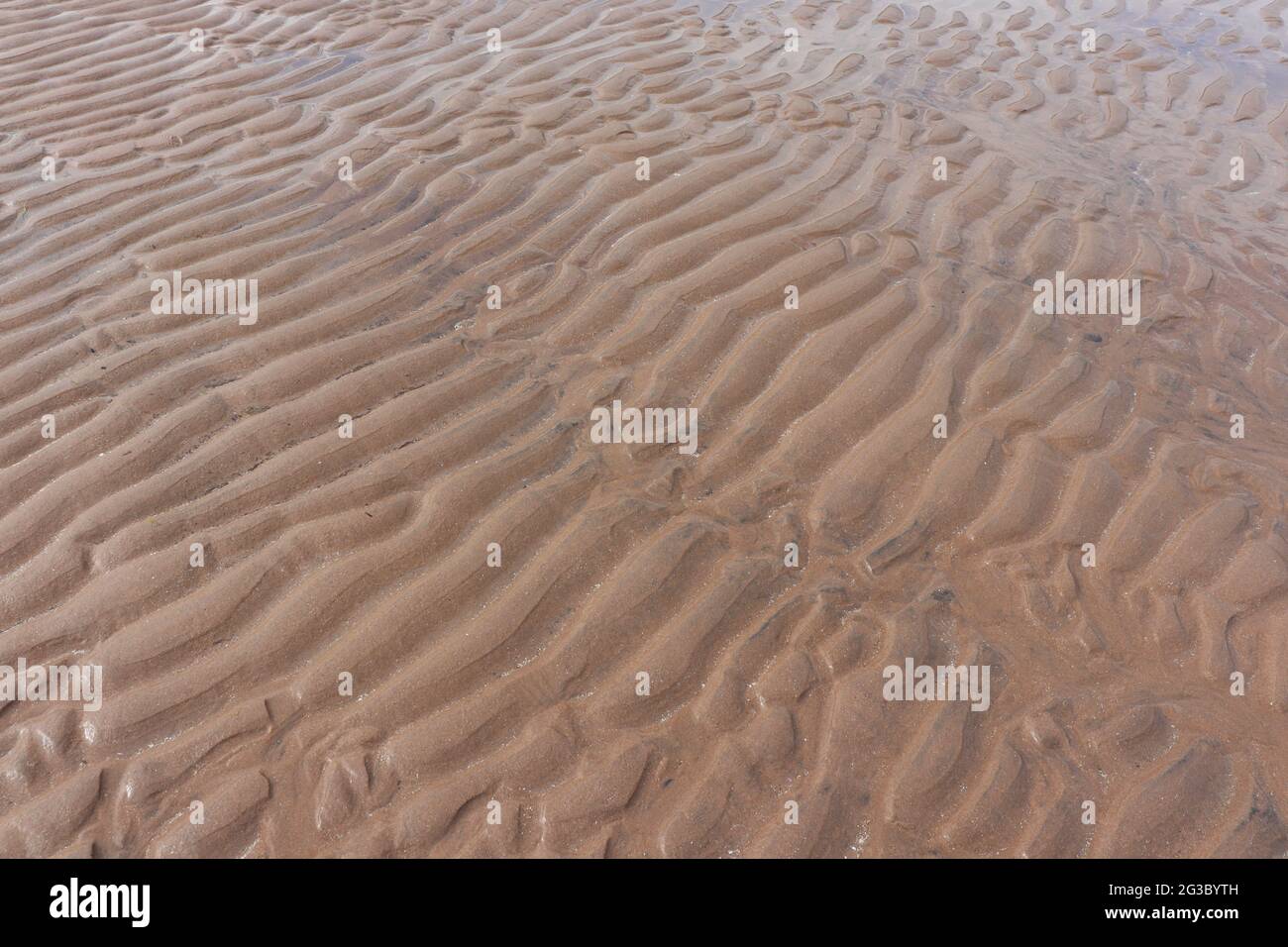 Lines, patterns and shapes in sand, formed by the tidal movement of the ...