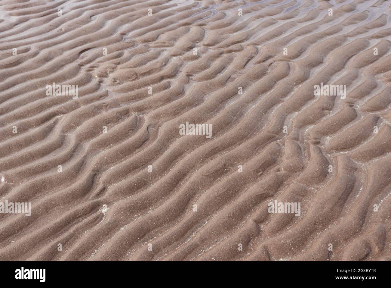 Lines, patterns and shapes in sand, formed by the tidal movement of the ...