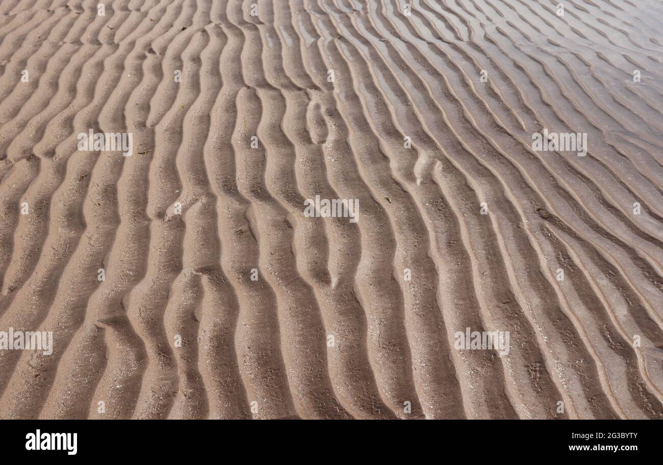 Lines, patterns and shapes in sand, formed by the tidal movement of the ...
