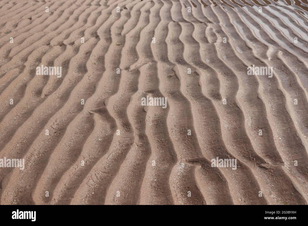 Lines, patterns and shapes in sand, formed by the tidal movement of the ...