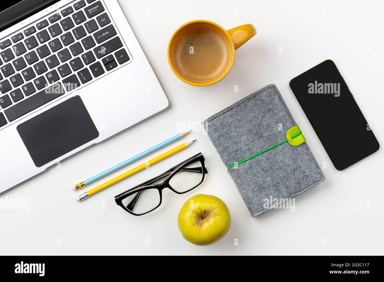 Flat lay top view modern laptop, food and stationery on white table ...