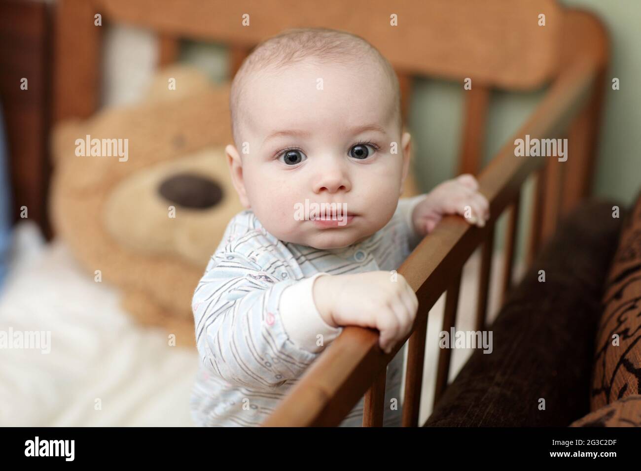 The pensive baby boy in cot at home Stock Photo - Alamy