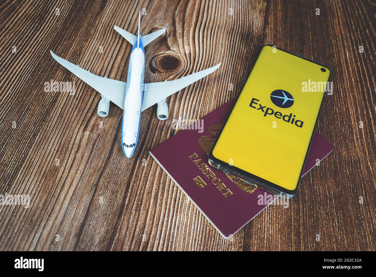 Smartphone with Expedia app logo with plane toy and red passport on ...