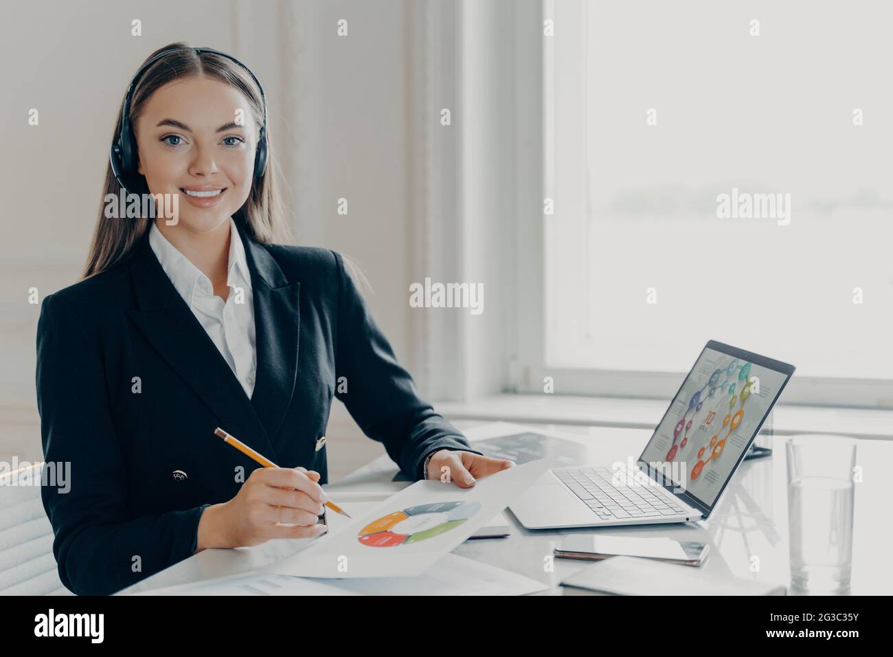 Professional business lady in headset preparing for online presentation ...
