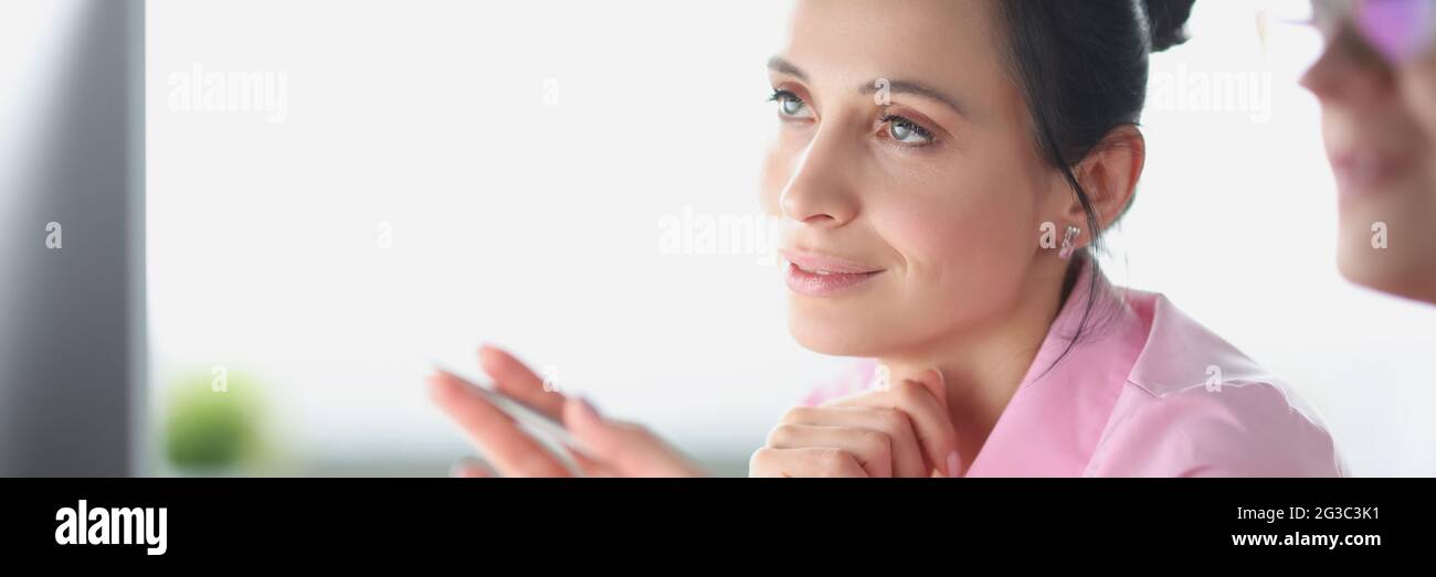 Two women looking at computer screen and communicate Stock Photo - Alamy
