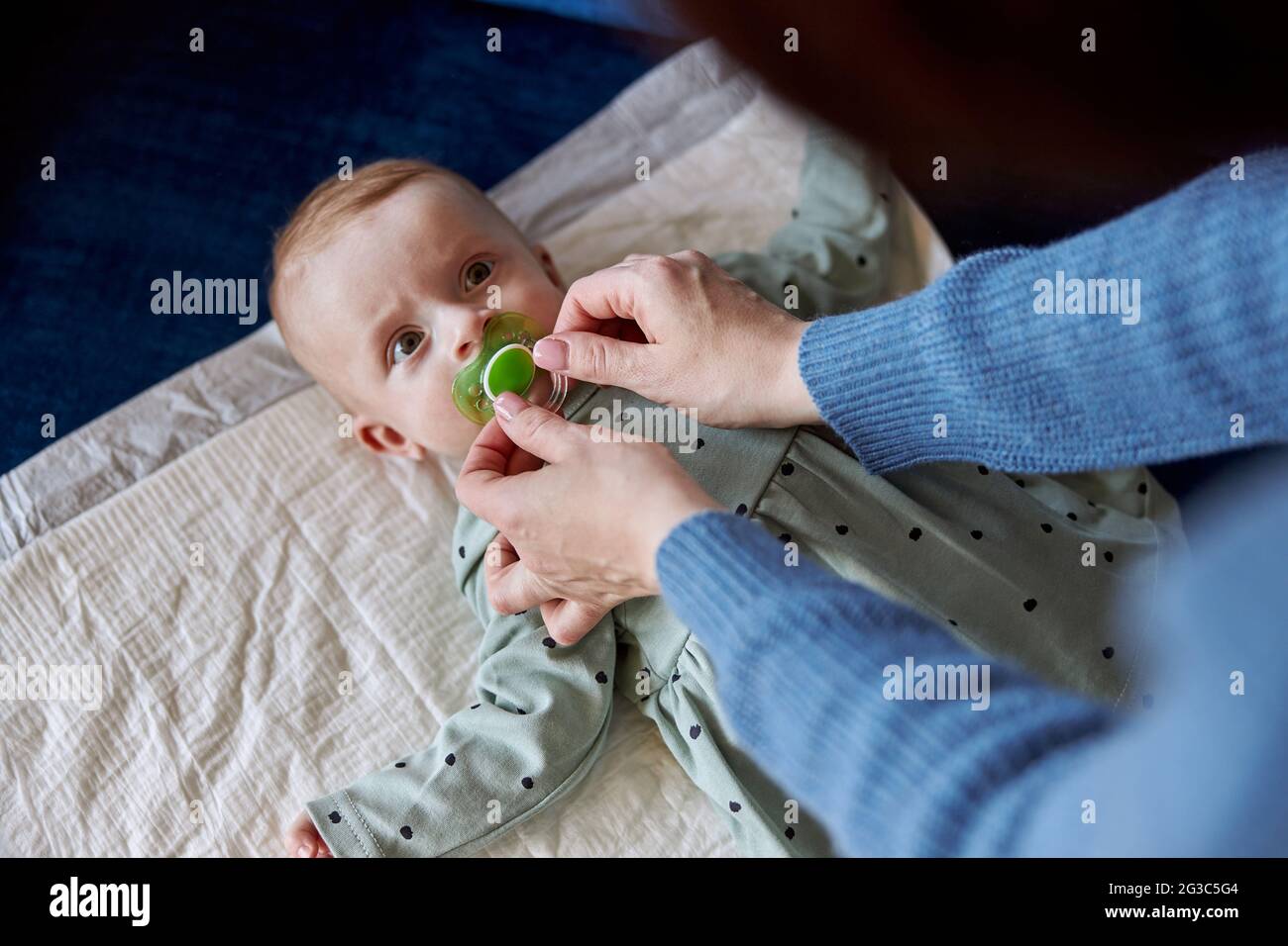 Mother giving pacifier into mouth of newborn baby Stock Photo - Alamy