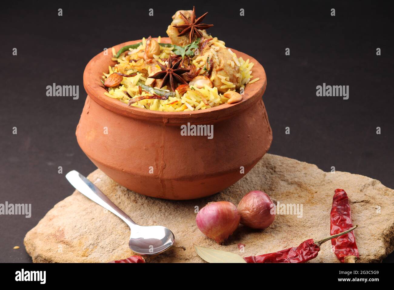 Spicy chicken dum biryani in traditional handi or clay pot. served with ...