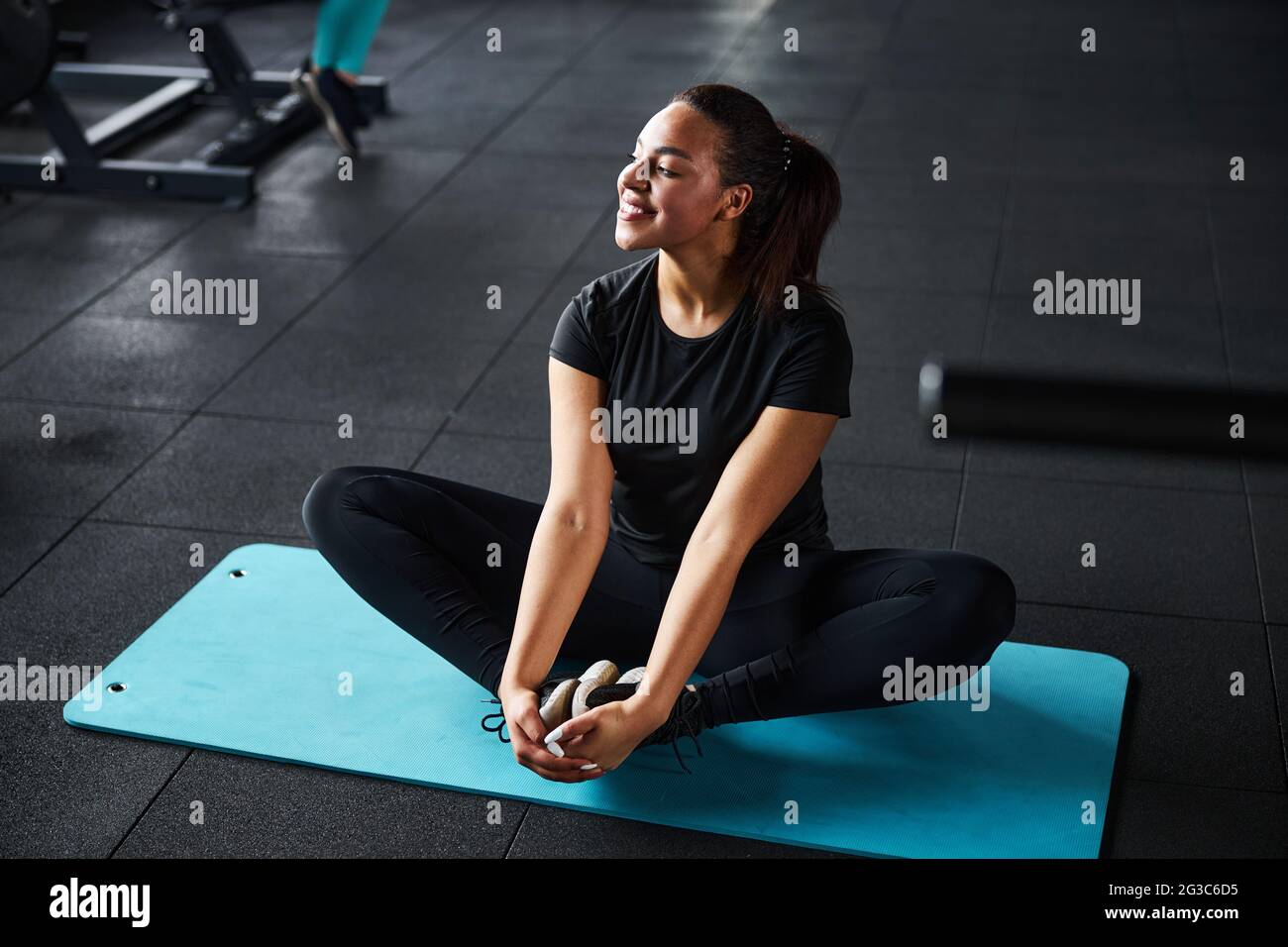 Happy pretty female enjoying stretching exercises indoors Stock Photo ...