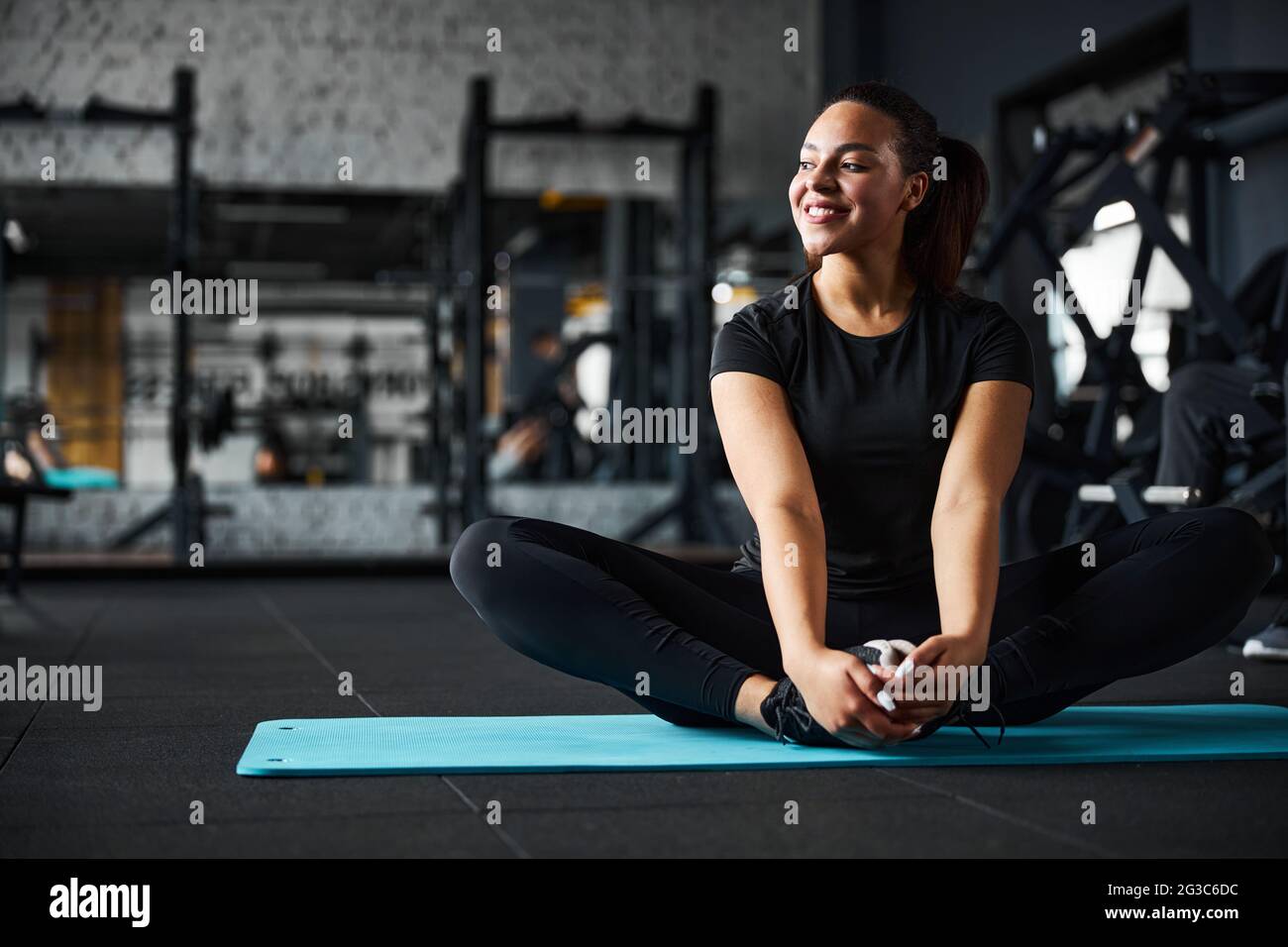 Serene pretty female doing mobility exercises in gym Stock Photo - Alamy