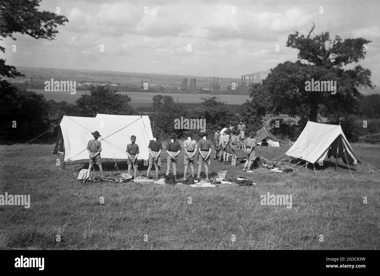 1951, historical, outside in a field, standing by their tents ...