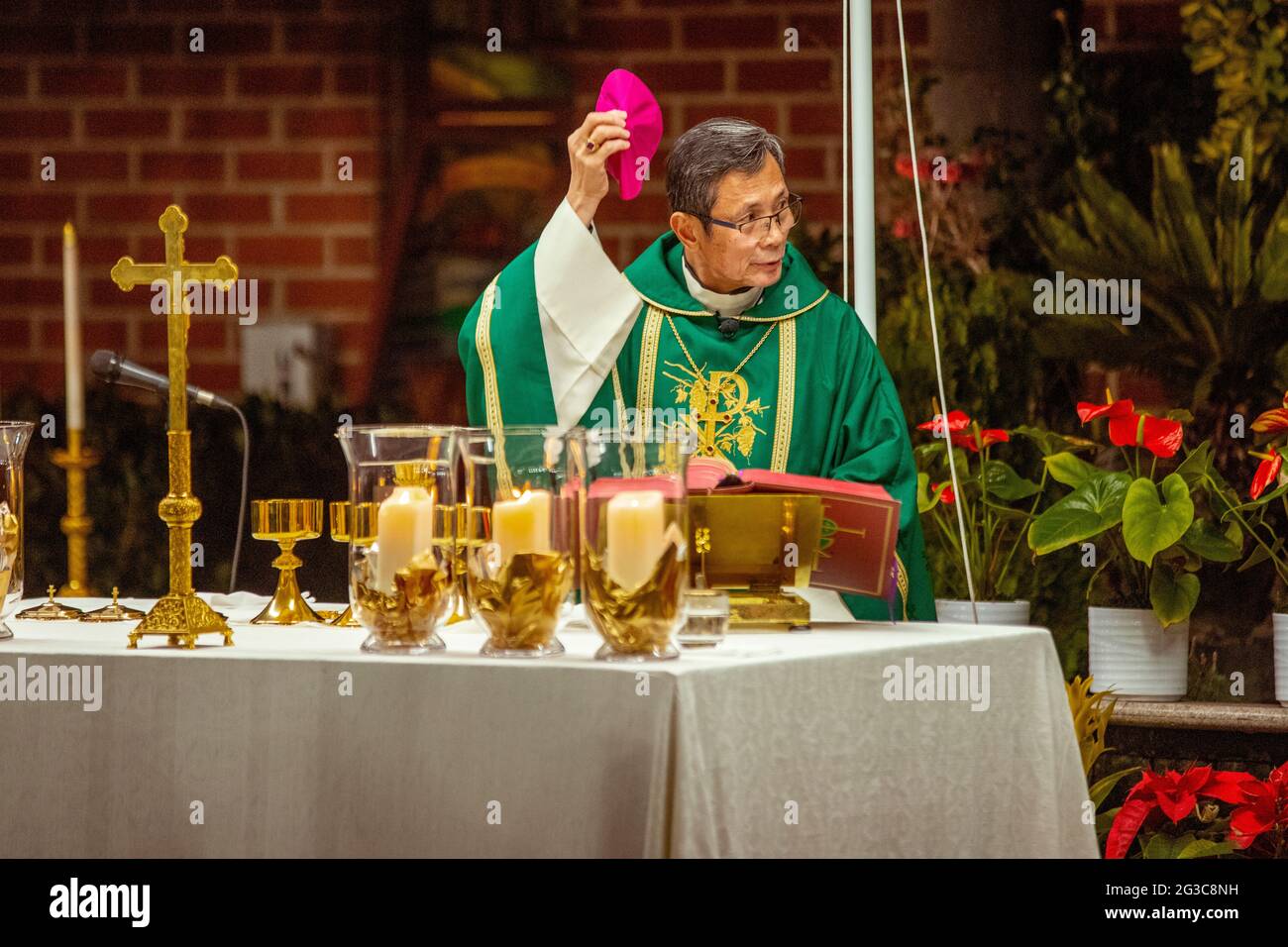 An Asian American priest doffs his cap at a mass for recognition of ...