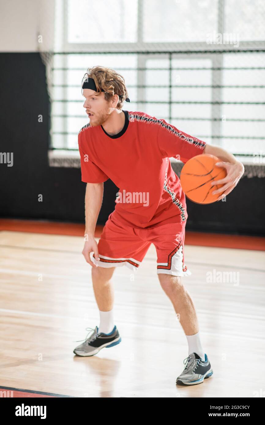 Ginger man in a red sportswear playing basketball Stock Photo - Alamy