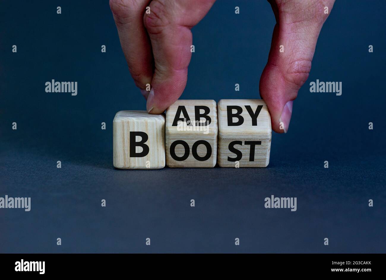 Baby boost symbol. Businessman turns wooden cubes and changes the word ...