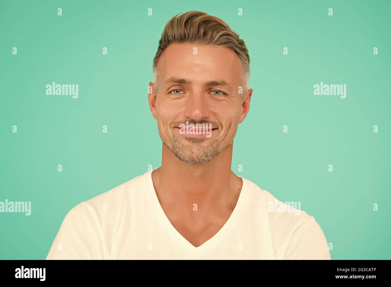 smiling guy with trendy hairstyle has colored graying hair and groomed ...