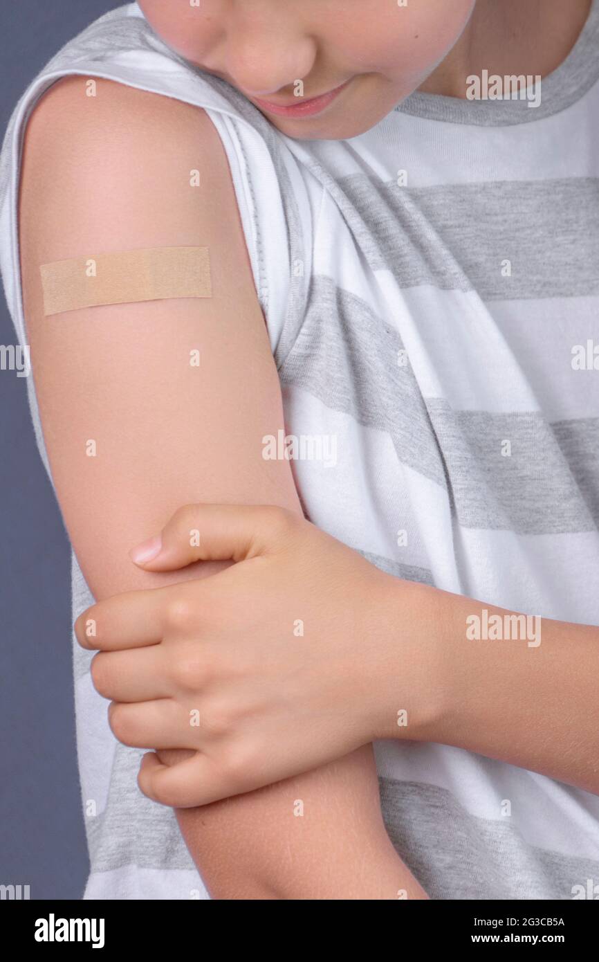 Teenage boy with adhesive bandage plaster on his arm after vaccination ...
