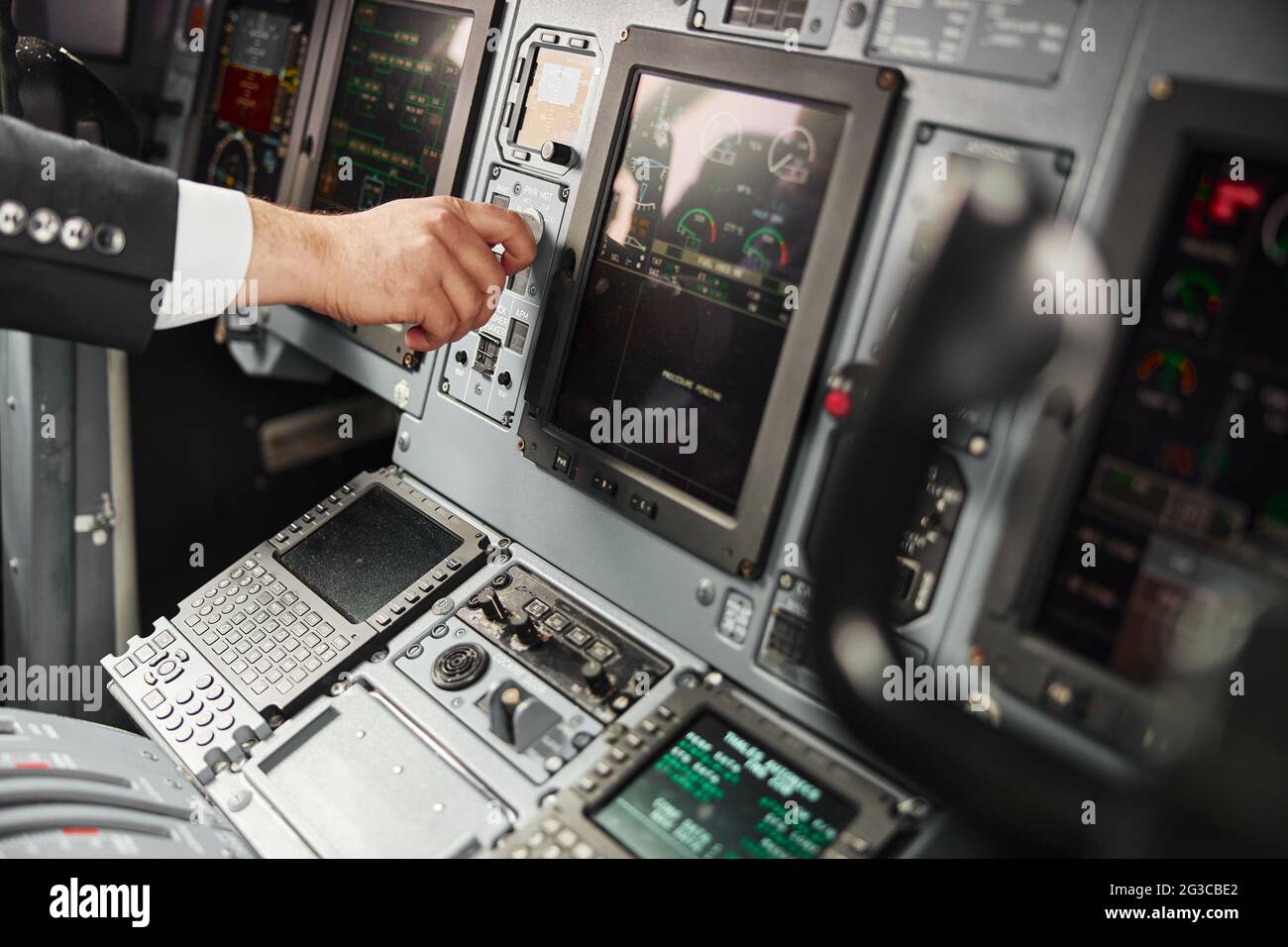 Male pilot turn button on passenger airplane jet Stock Photo - Alamy