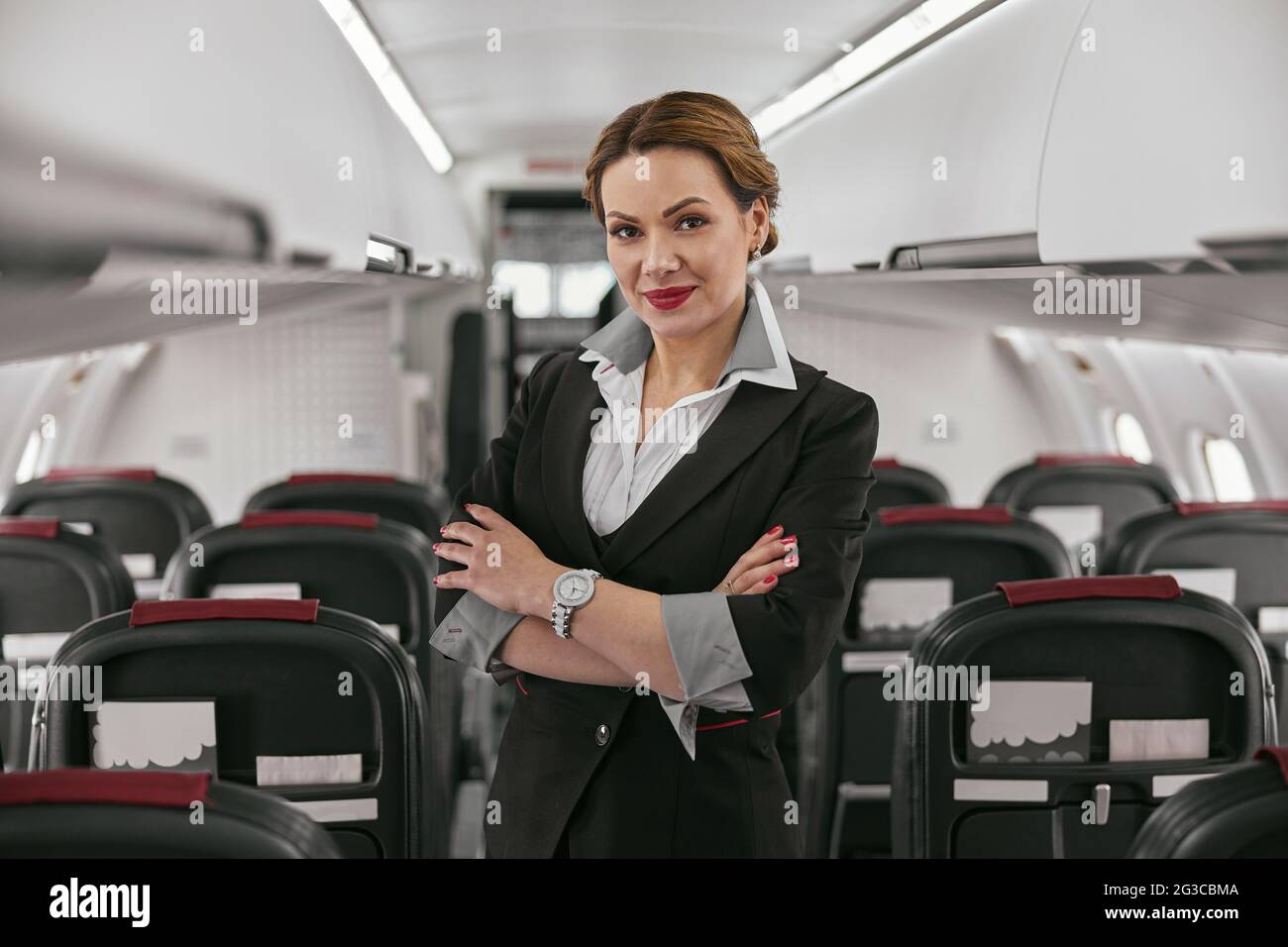 Stewardess in passenger cabin of airplane jet Stock Photo - Alamy