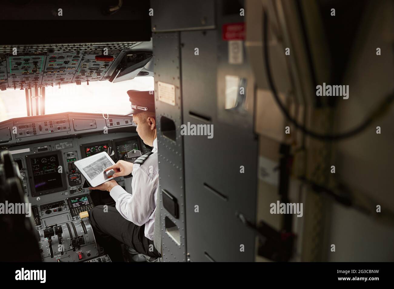 Pilot use digital tablet in passenger airplane jet Stock Photo - Alamy