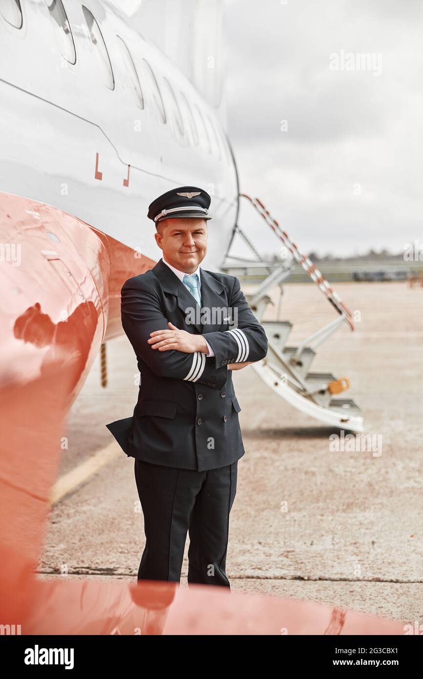 Pilot standing on runway near airplane jet Stock Photo - Alamy