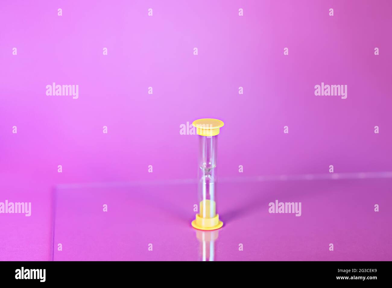 Yellow hourglass on pink background. sandglass with sand inside to ...