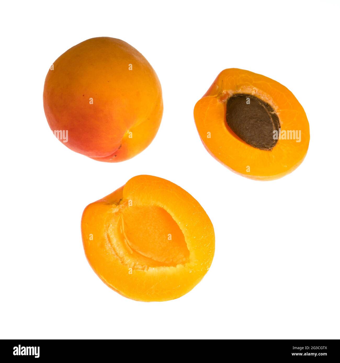 Ripe apricot fruits, one whole and divided into pieces, on a white ...