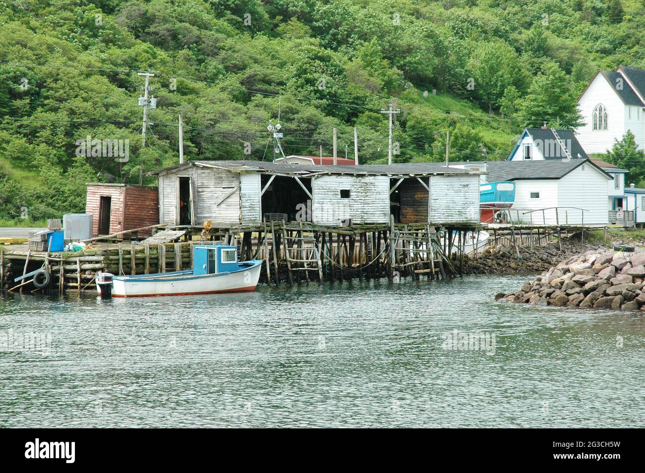 Weathered fishing shack with storage containers and a docked fishing ...