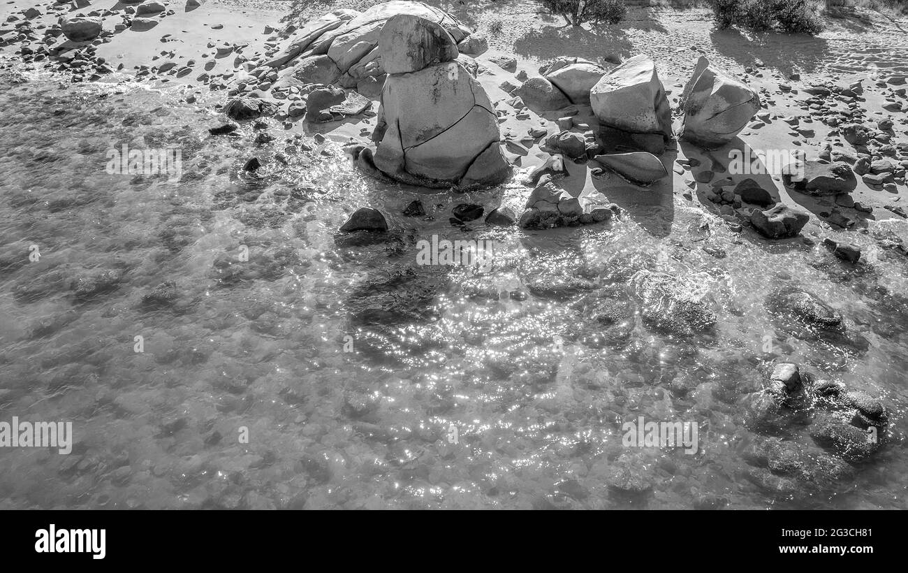 Aerial of a tall rock formation on the beach at low tide, rendered in ...