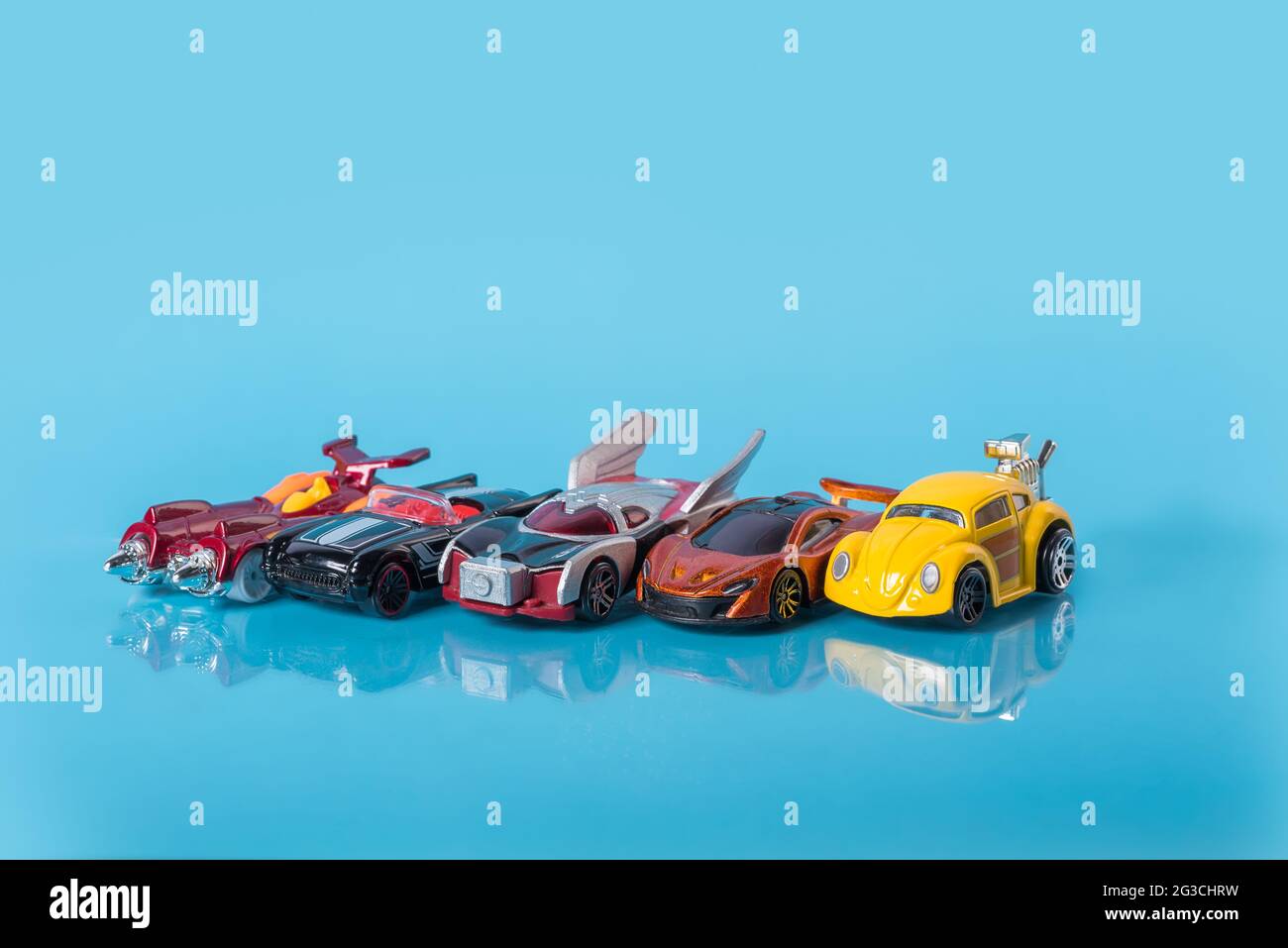 Many multi-colored toy cars on blue background, small car models Stock ...