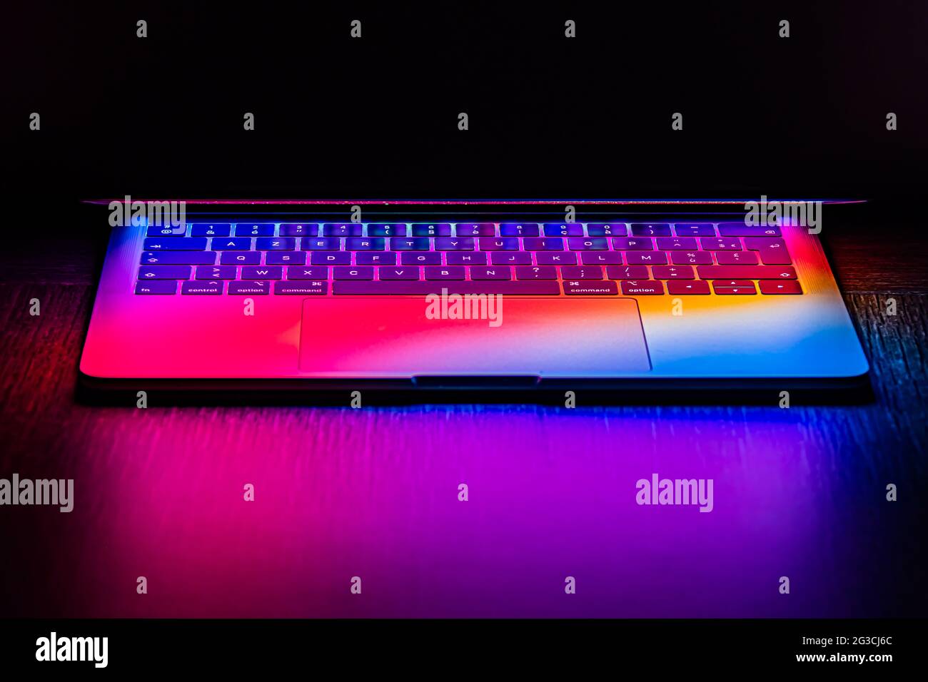 Laptop in dark room with screen giving light Stock Photo - Alamy